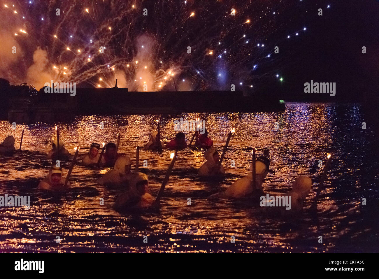 Ama women swimming in the sea holding torches at night with fireworks ...