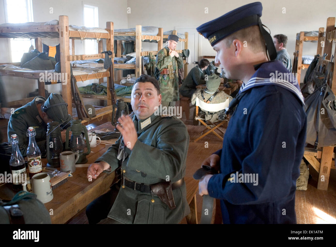 World War II reenactors wearing german uniforms chat inside a barrack ...