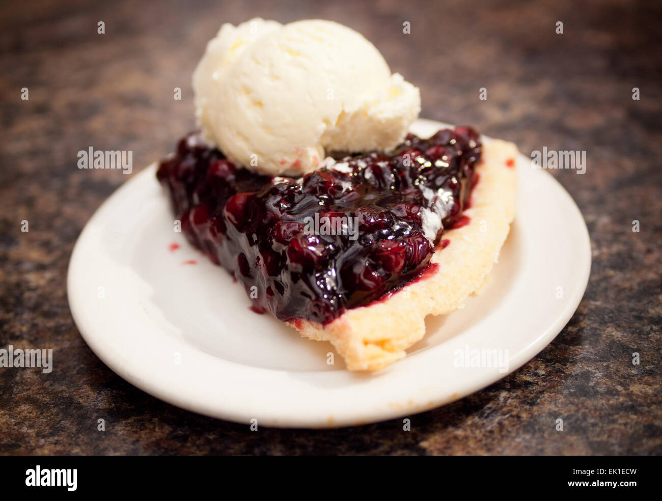 A slice of Saskatoon berry pie and a scoop of vanilla ice cream from ...