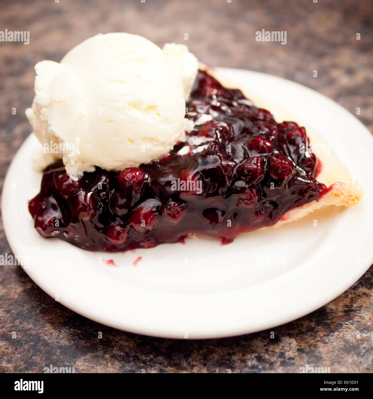 A slice of Saskatoon berry pie and a scoop of vanilla ice cream from ...