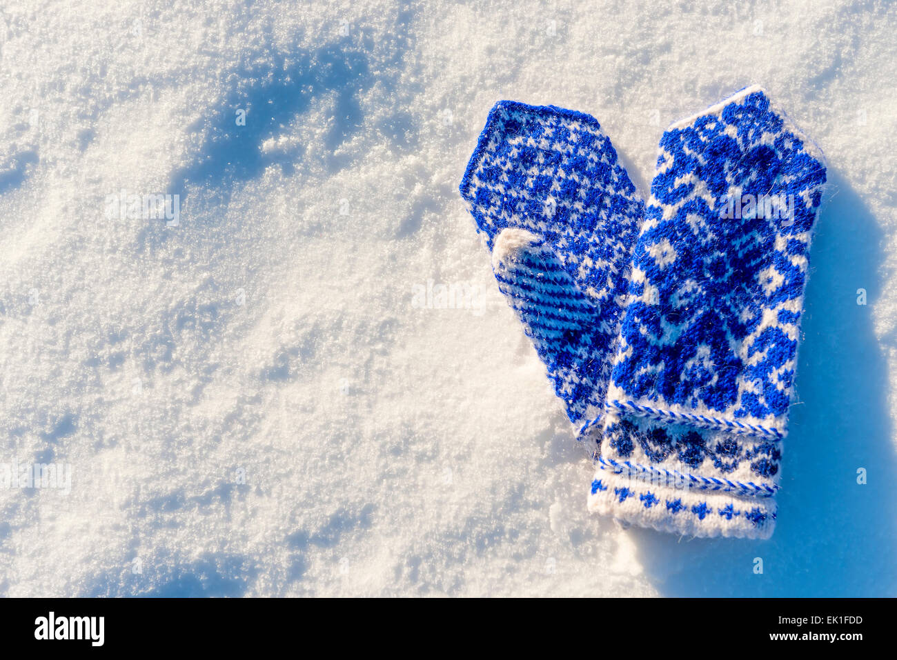 warm woolen mittens with beautiful pattern lying in the snow Stock ...