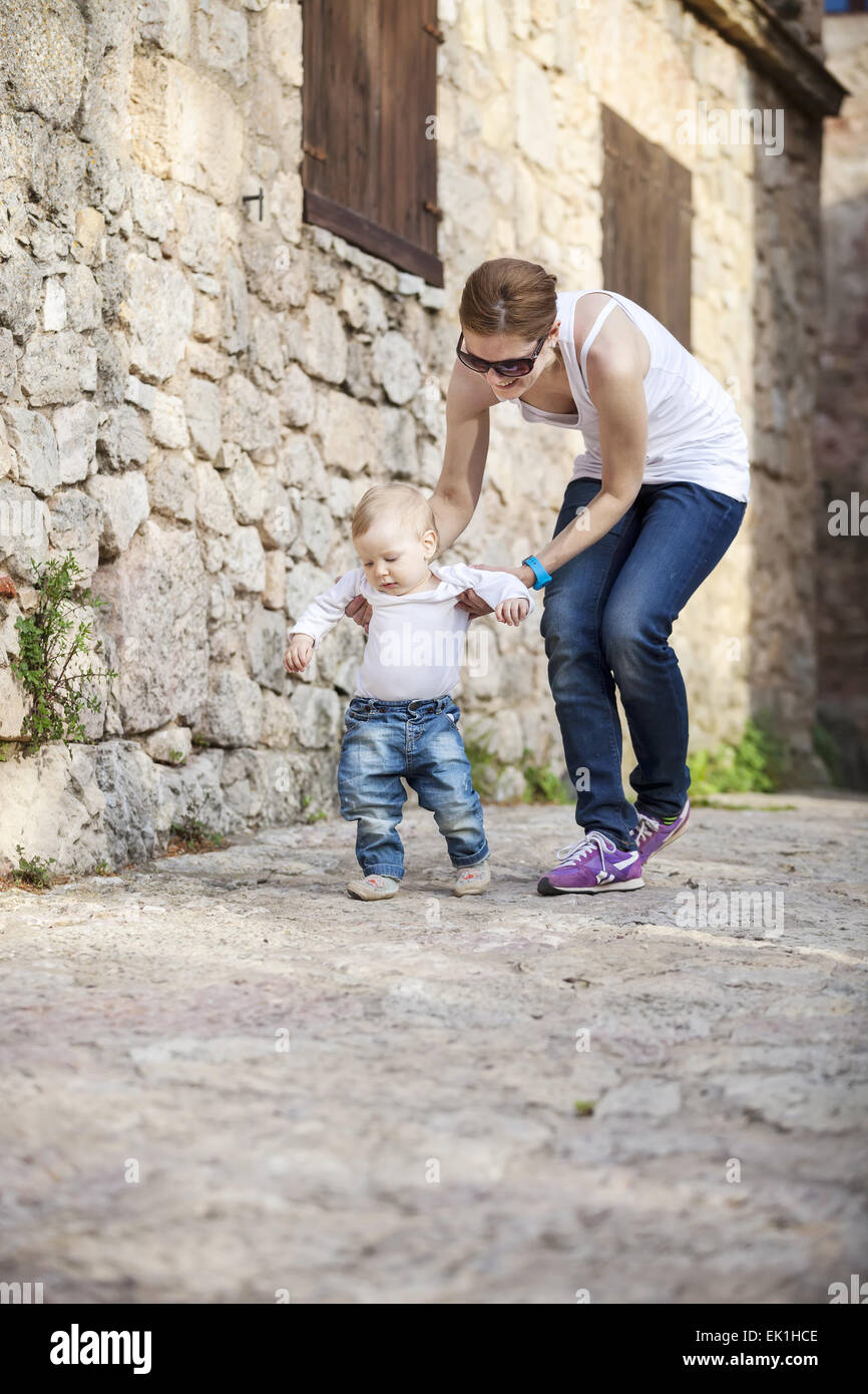 Cute baby boy makes his first steps with help of his mother Stock Photo ...