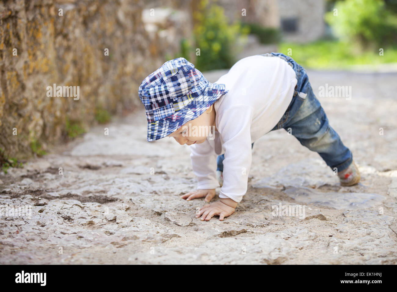 Cute little boy crawling on stone paved sidewalk Stock Photo - Alamy