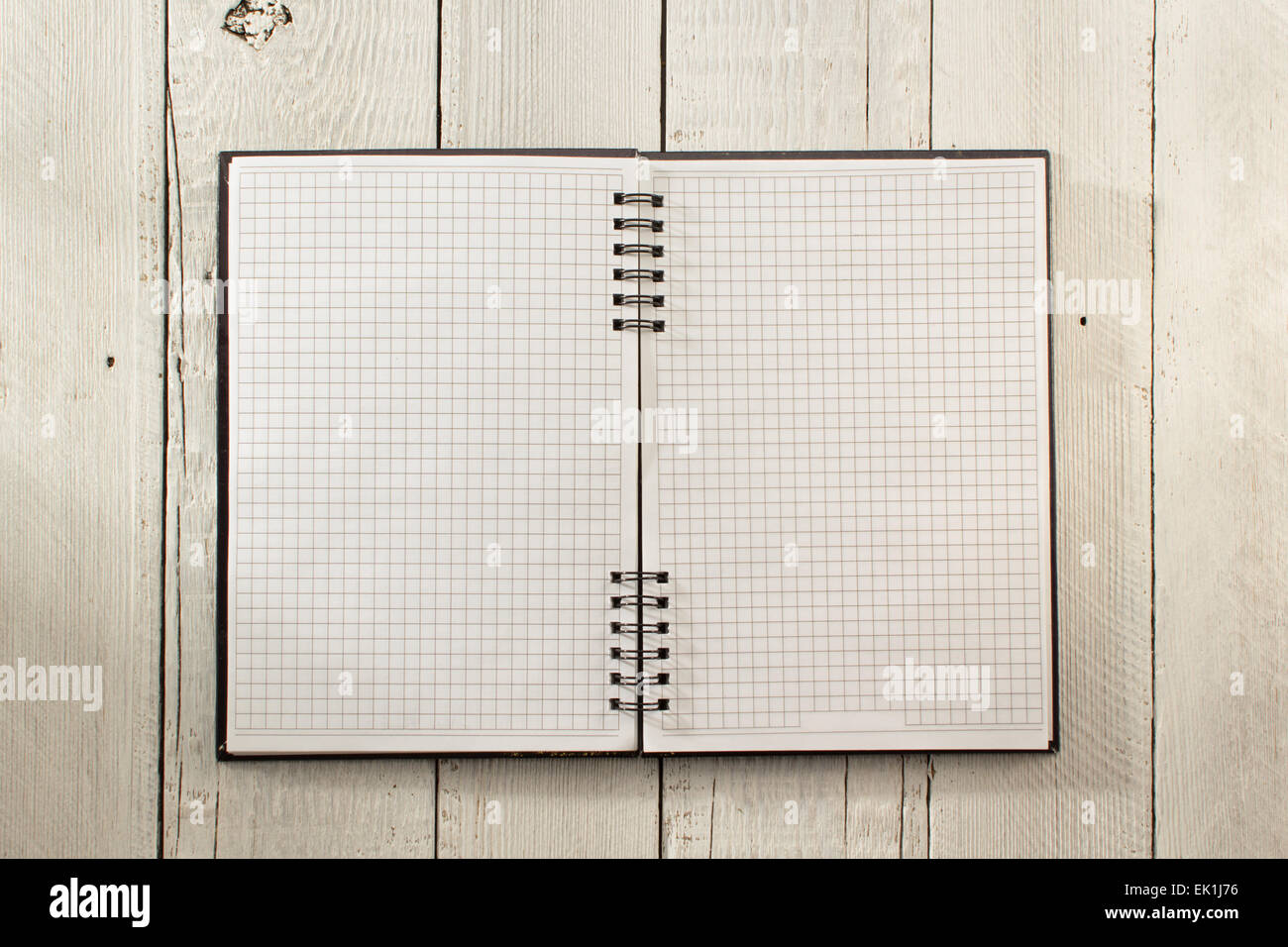 checked notebook on wood background Stock Photo - Alamy