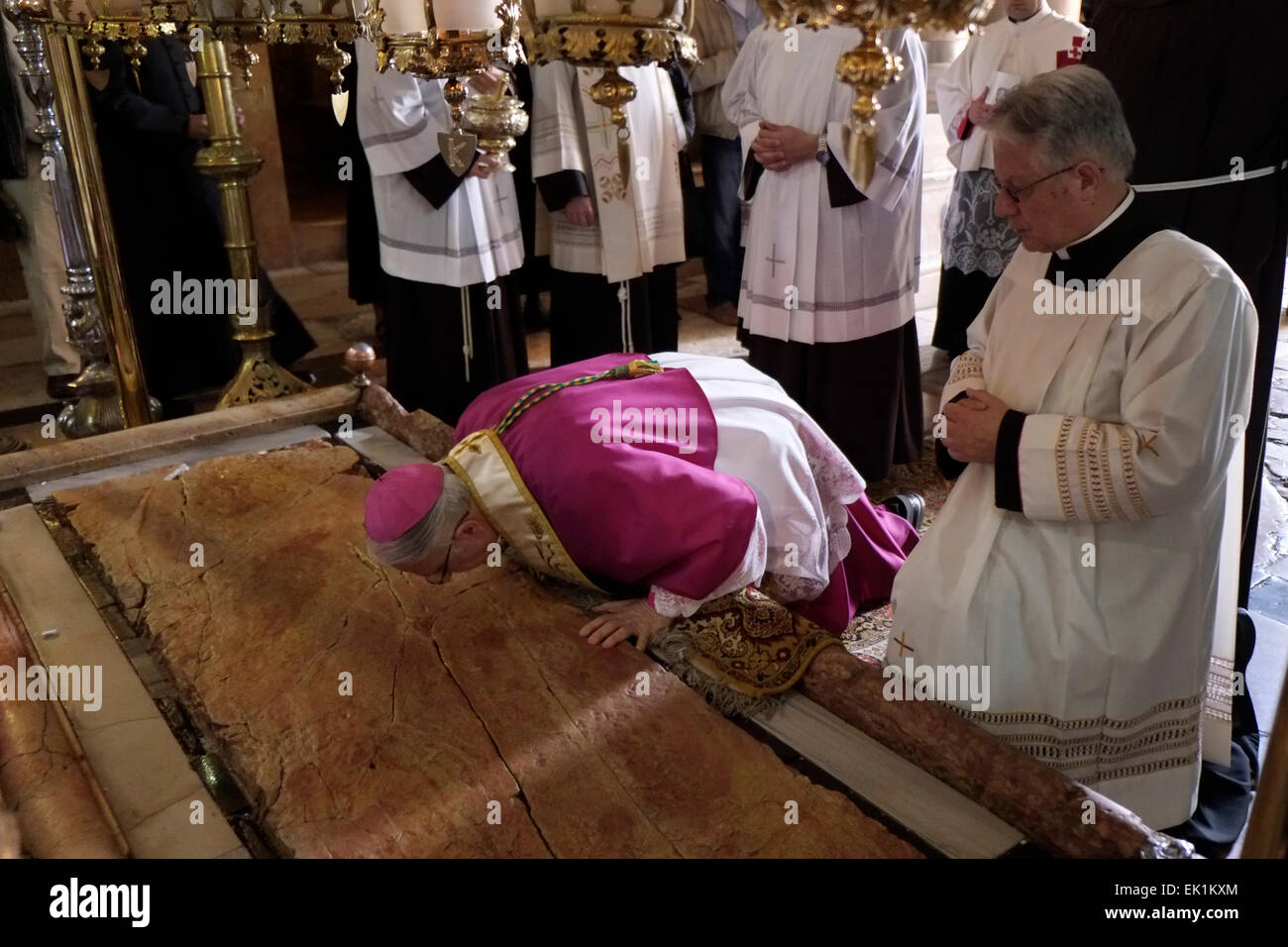 Latin Catholic cleric prays prostrated at the Stone of the Anointing or ...