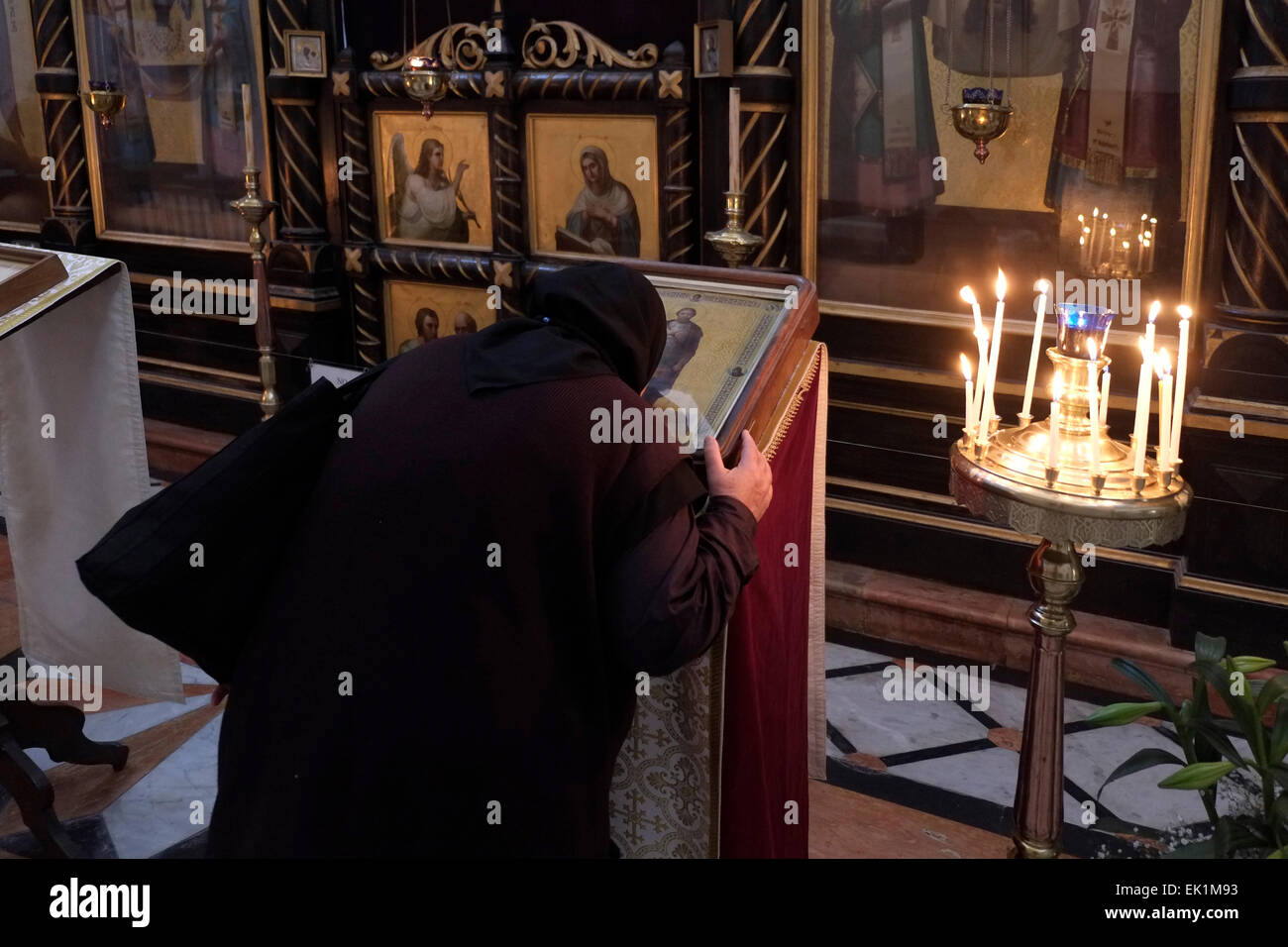 A Russian Orthodox pilgrim kissing a religious icon at the Church of ...
