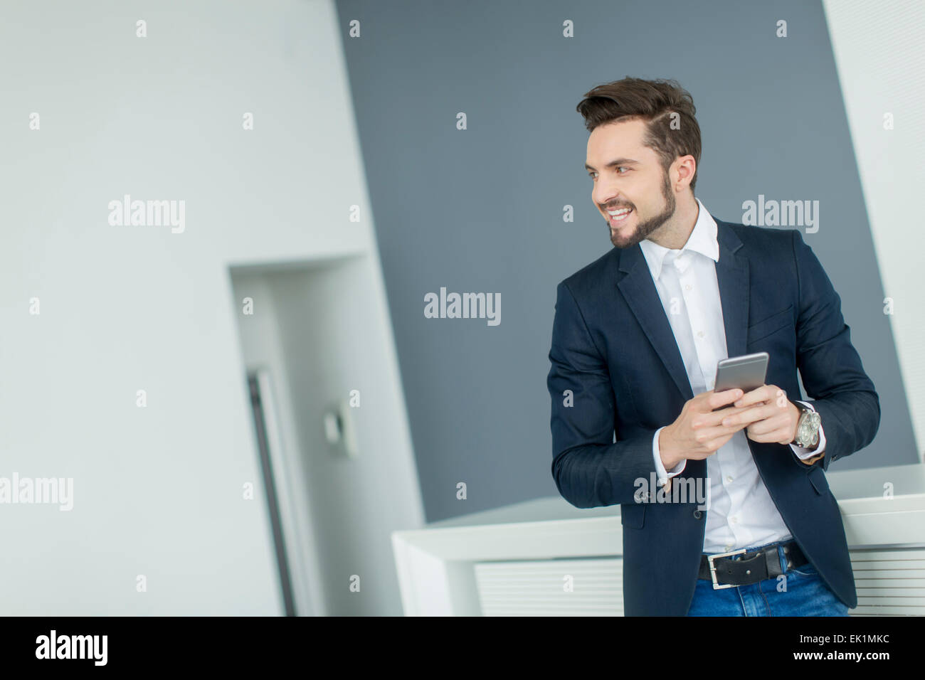Young man with mobile phone in the office Stock Photo - Alamy