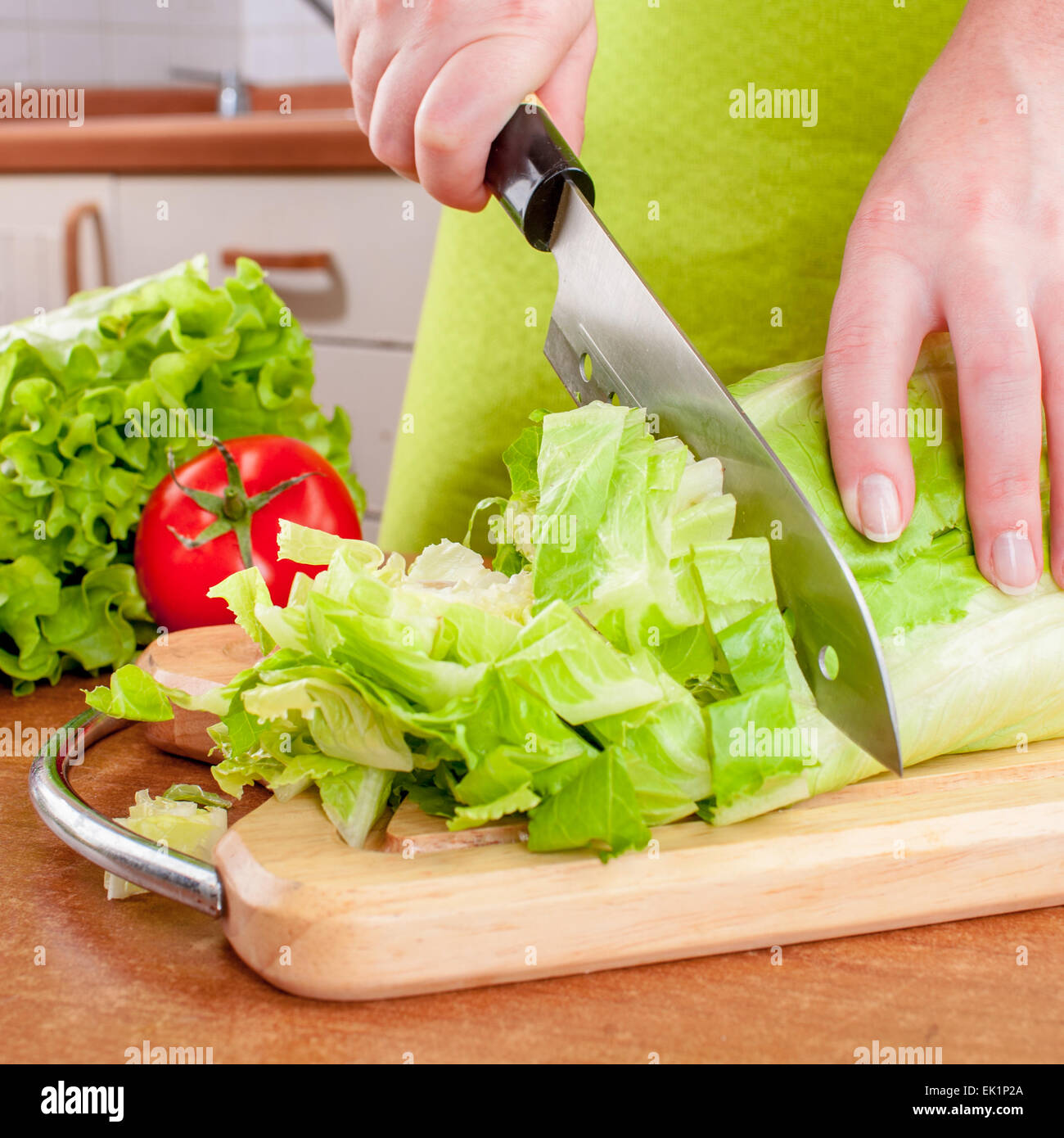 Woman's hands cutting lettuce, behind fresh vegetables Stock Photo - Alamy