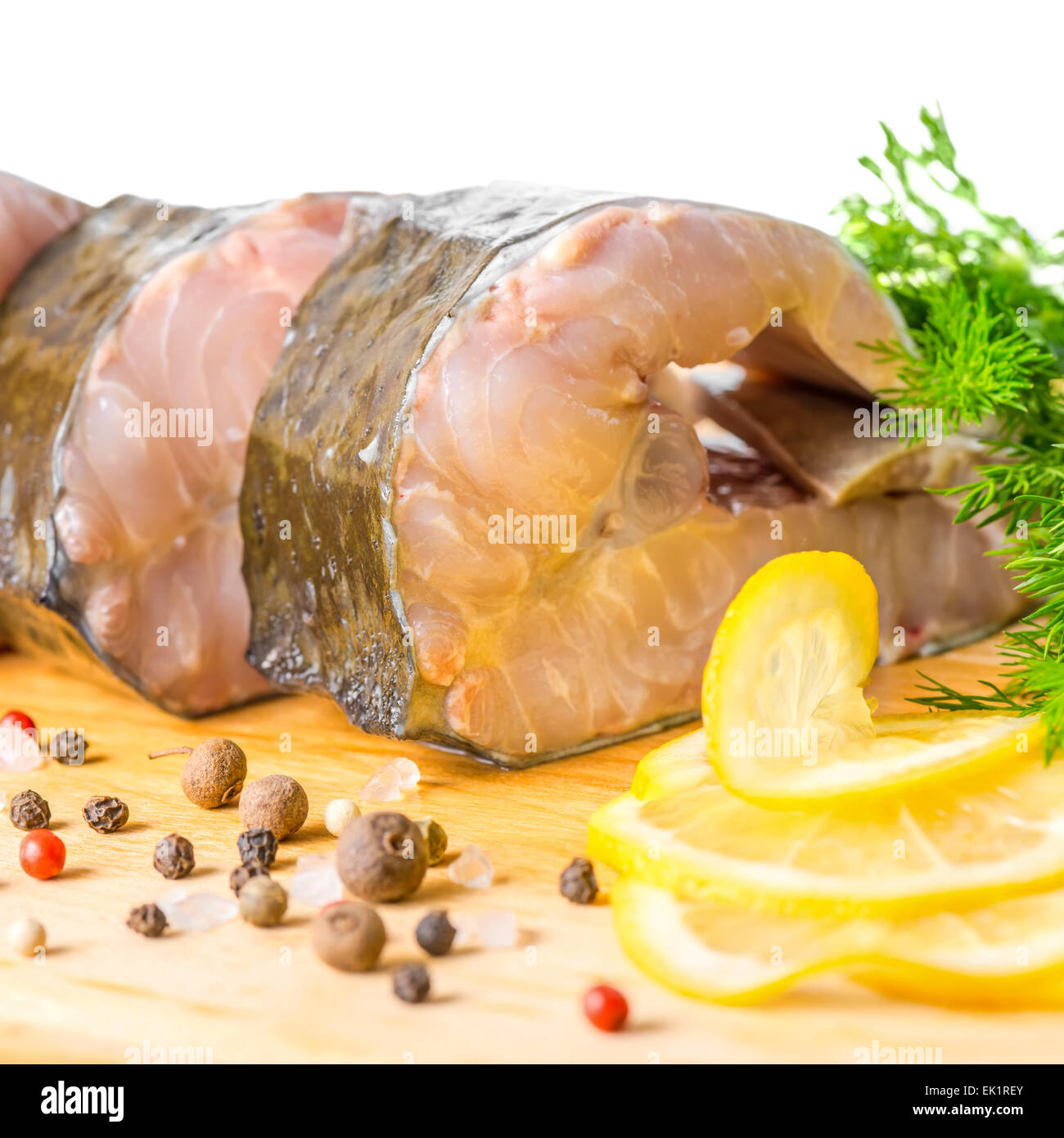 raw fillet steak of sturgeon fish with greens, lemon, different peppers ...