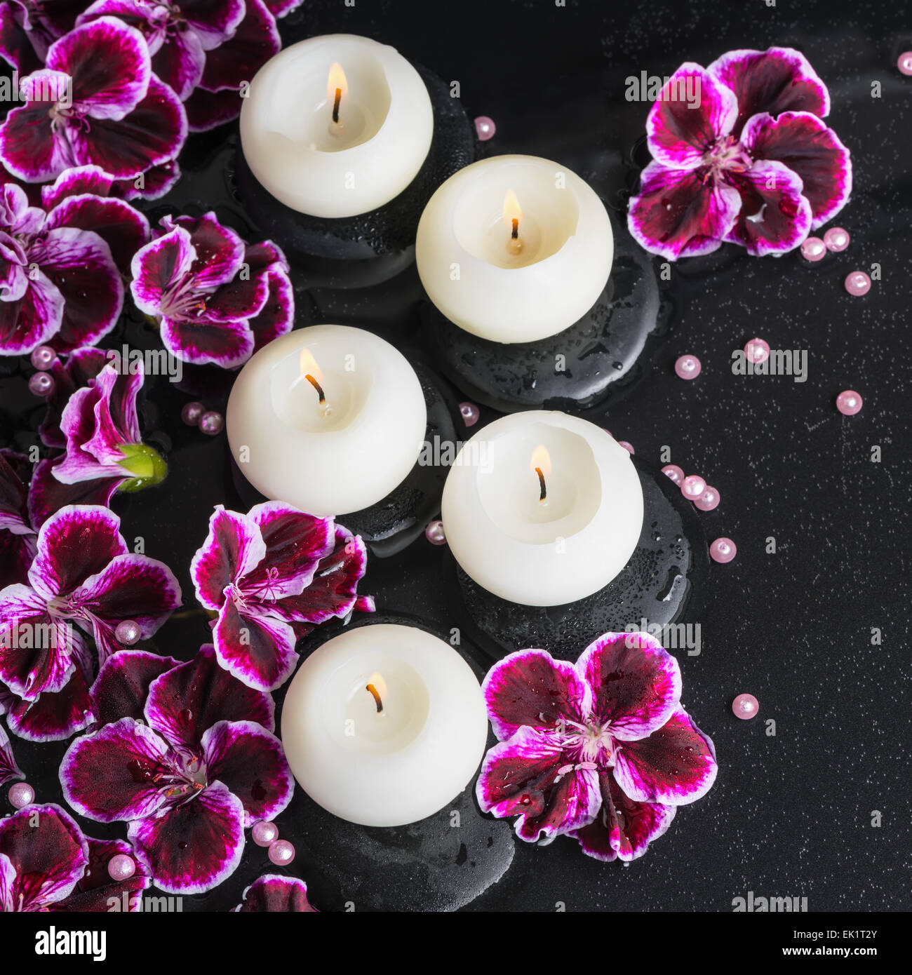 beautiful spa still life of geranium flower, beads and candles in ...