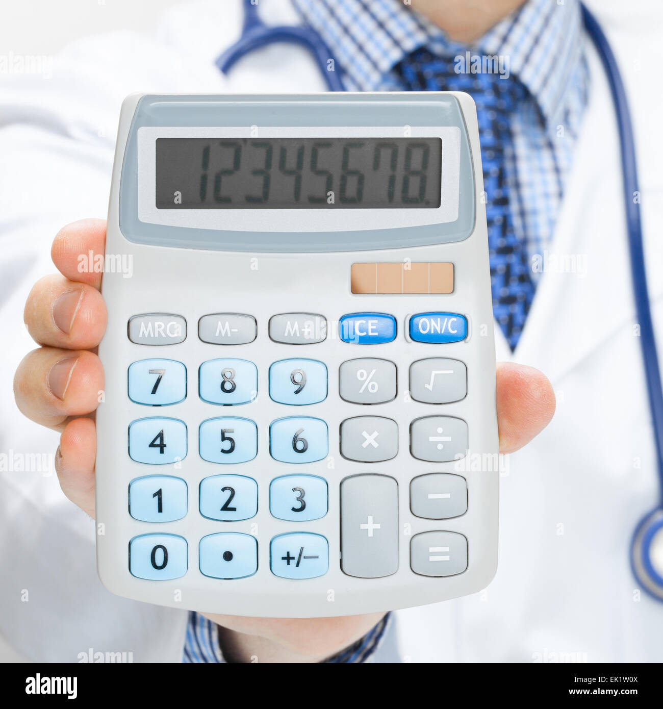 Doctor holding calculator in hand - health care concept - studio shot ...