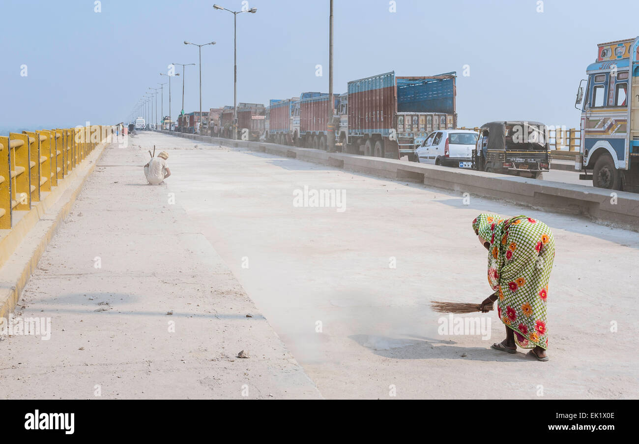 Construction workers prepare a lane of the 10 km long Mahatma Gandhi ...