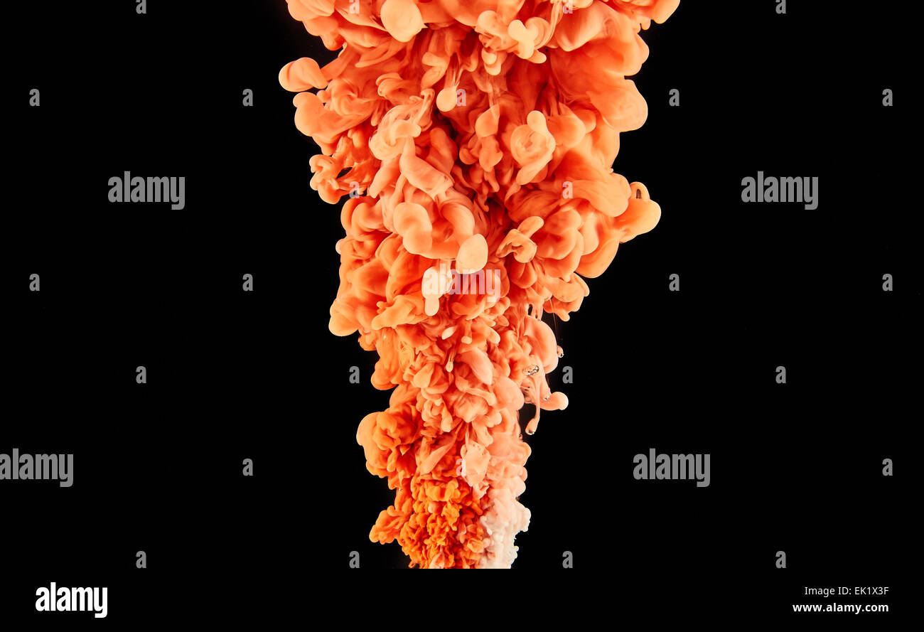 Clay colored ink making smoke patterns in water on black background ...