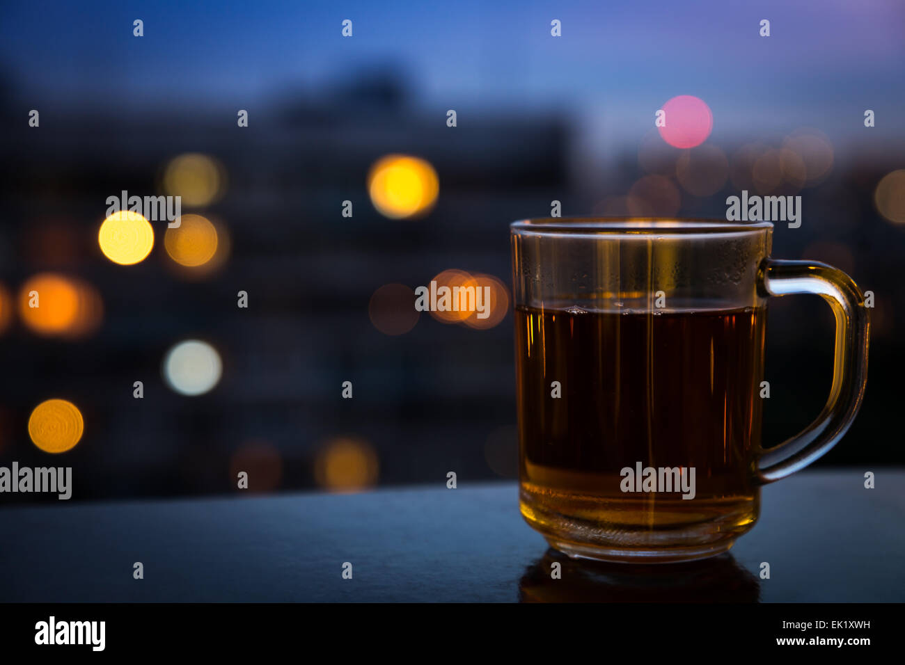 Tea cup in front of night city lights Stock Photo - Alamy