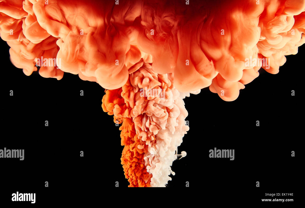 Clay colored ink making smoke patterns in water on black background ...