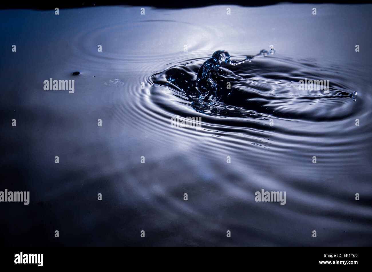 Drop of water splashing on surface Stock Photo - Alamy