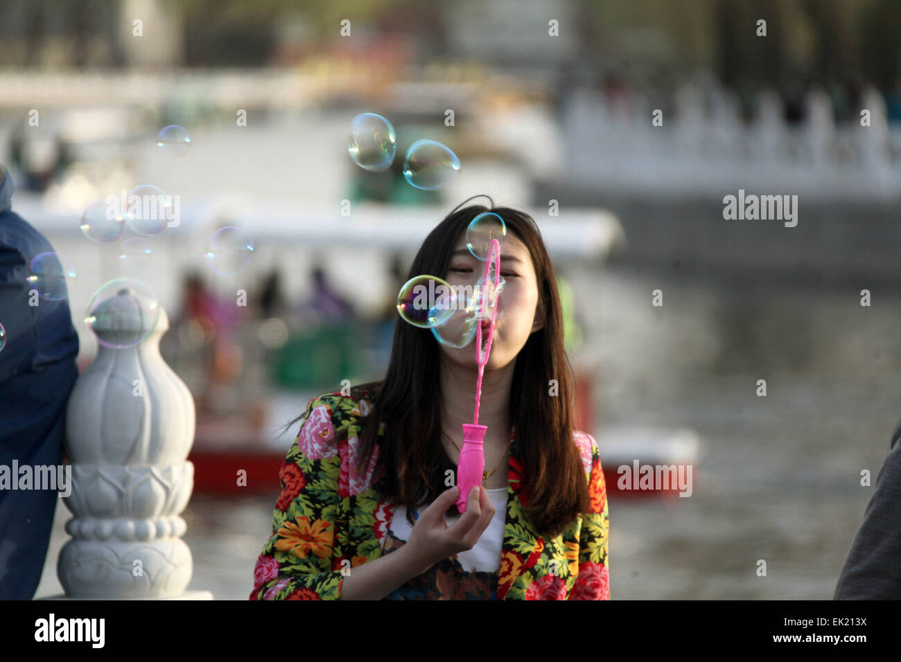 Beijing, China. 3rd Apr, 2012. A woman is making bubbles on bridge at ...