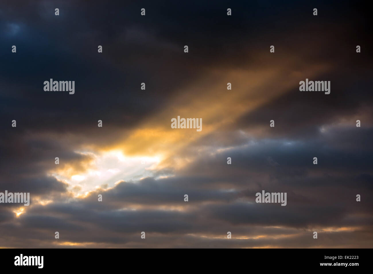 A beam of sun light breaks through heavy clouds during sunset in London ...