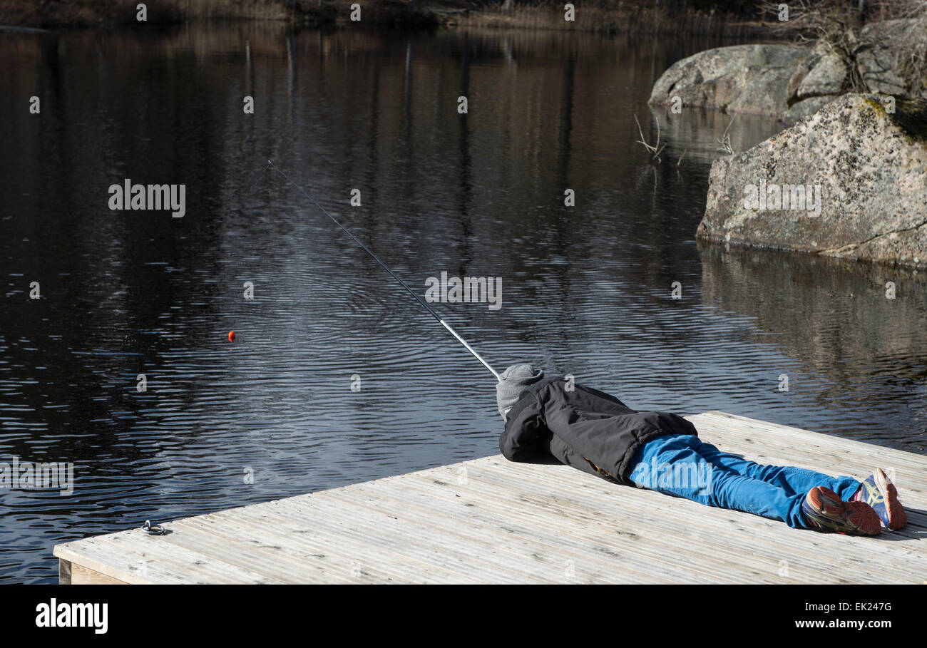 Young boy looking for fish while fishing Stock Photo - Alamy