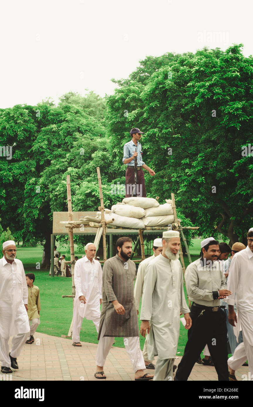 Security guard watching worshippers going to mosque Stock Photo - Alamy
