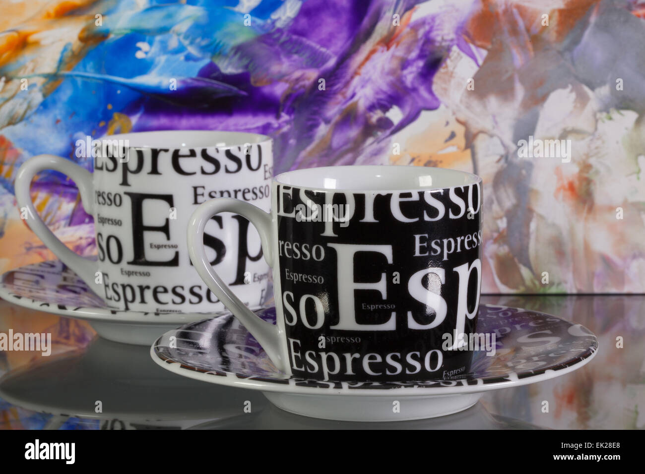 Two empty coffee cups on a glass plate in front of colored paper Stock ...