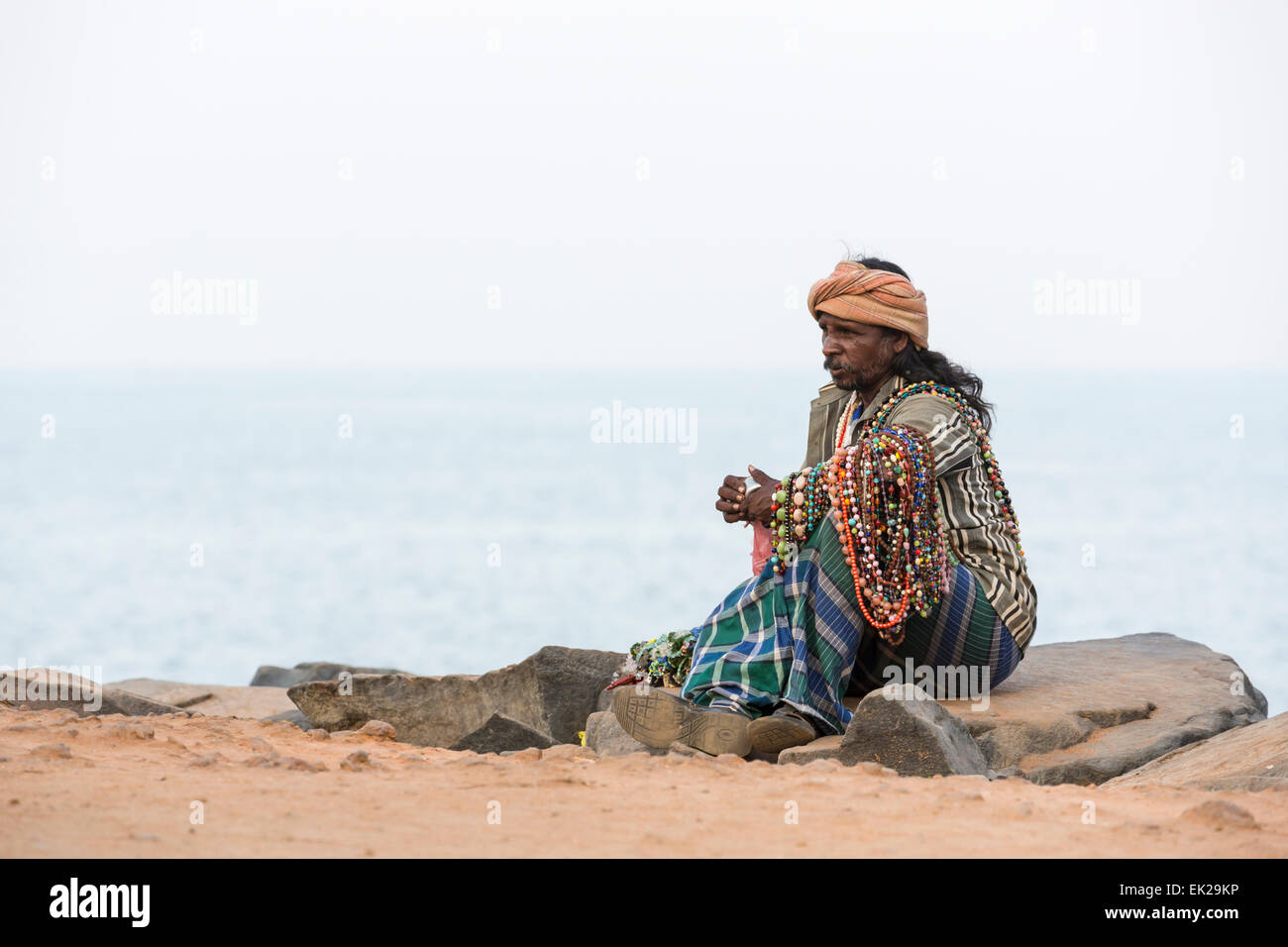 Local man sitting on rocks selling necklaces, beads and trinkets as ...