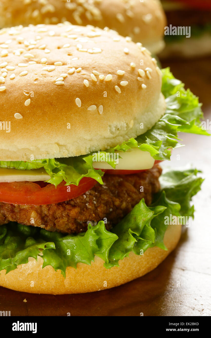 traditional cheeseburger with green lettuce and tomatoes Stock Photo ...