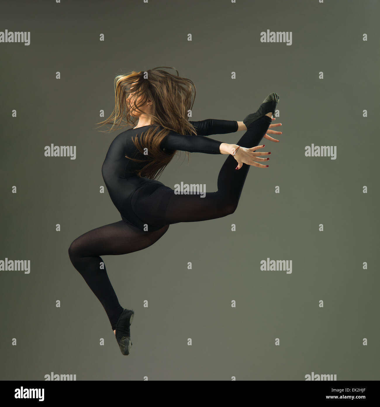 female dancer jumping against grey background Stock Photo - Alamy