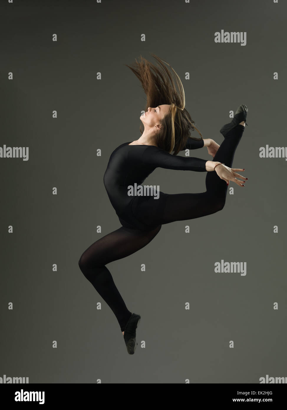 beautiful woman performing dance moves against grey background Stock ...