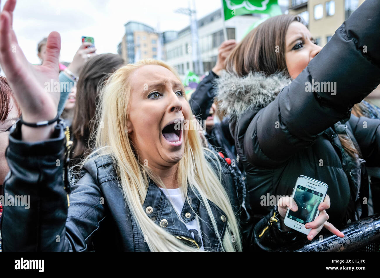 A young teenage girl starts screaming and crying with excitement at a ...