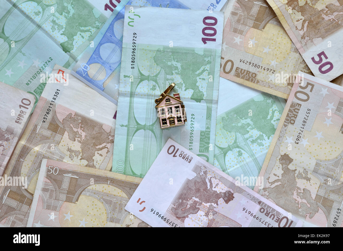 Money as a background and a small house Stock Photo - Alamy