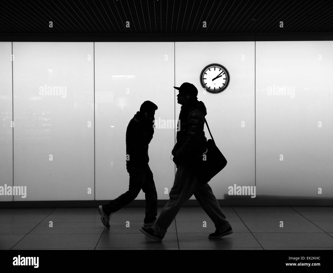 Urban City Commuters hurry commuting under wall clock. Modern commuters ...