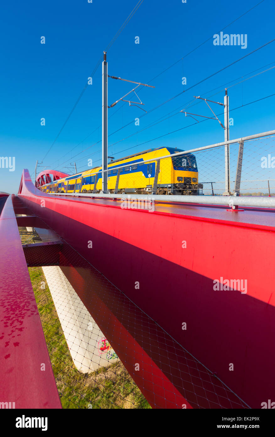 train passing the new red railroad bridge over the IJssel river in the ...
