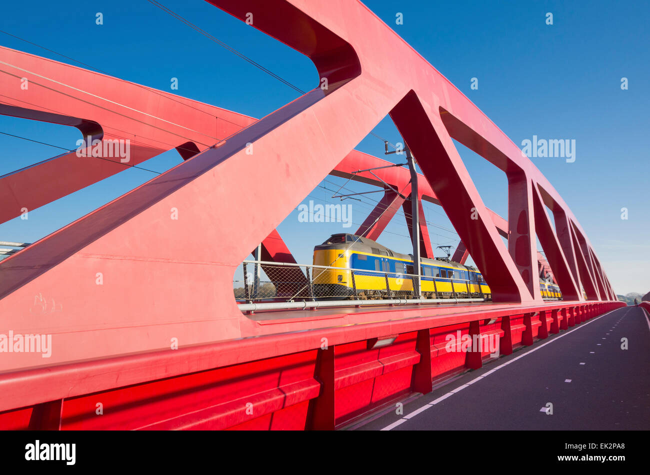 train passing the new red railroad bridge over the IJssel river in the ...