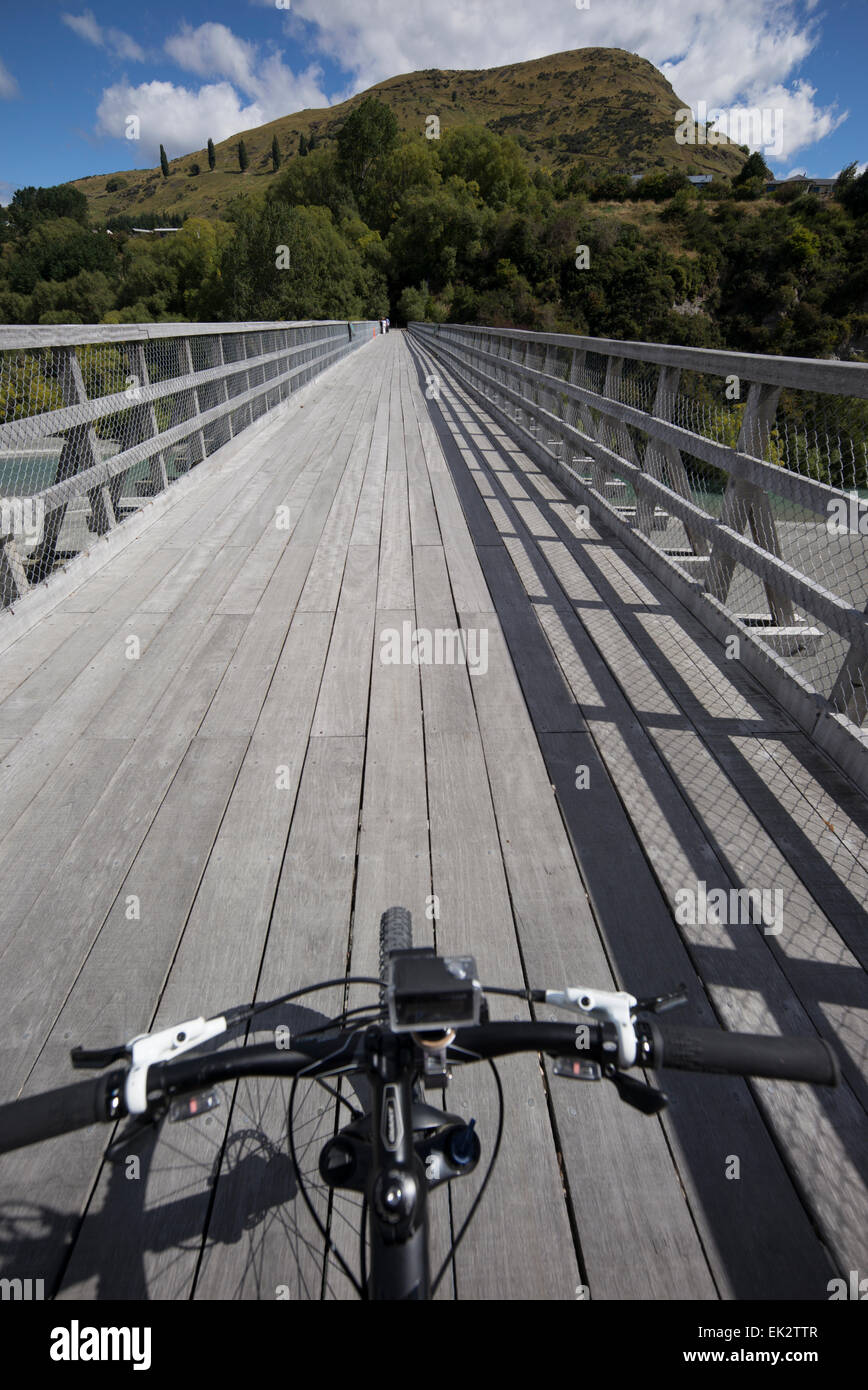Cycling across the historic Shotover Bridge, Queenstown, New Zealand ...