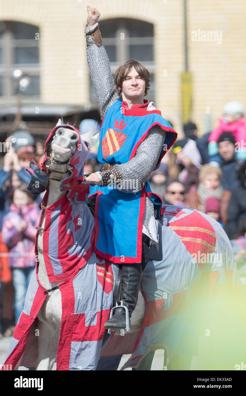 Actors dressed as knights ride across a square during a medieval castle ...