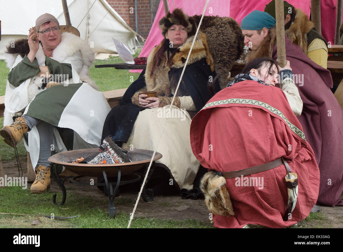 Actors dressed in medieval garb try to keep warm during a medieval ...