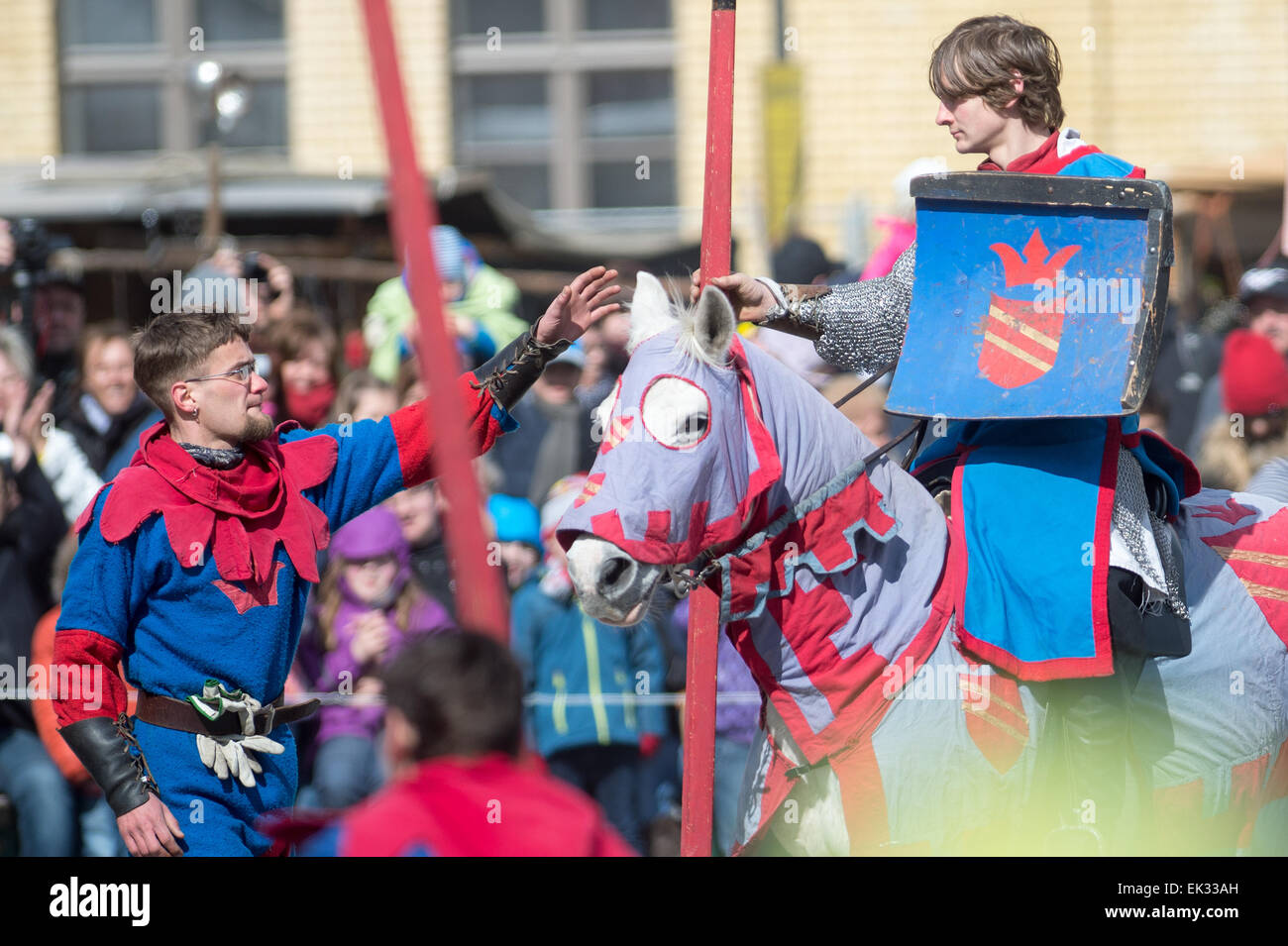 Actors dressed as knights ride across a square during a medieval castle ...