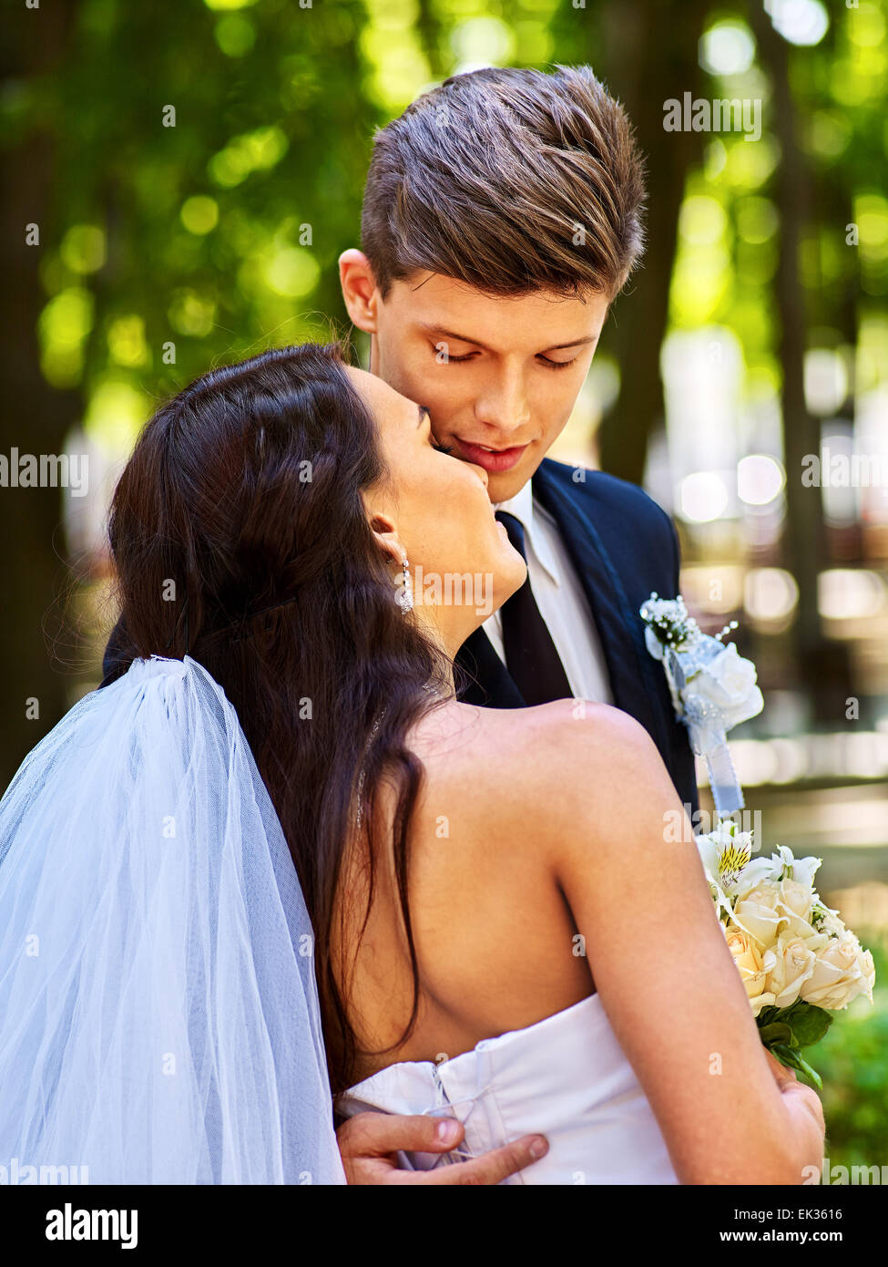 Groom kissing bride on shoulder Stock Photo - Alamy