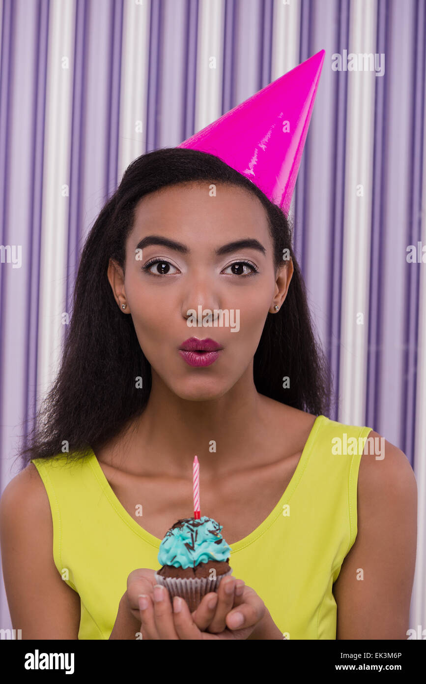 African-american woman with birthday hat and small cupcake Stock Photo ...