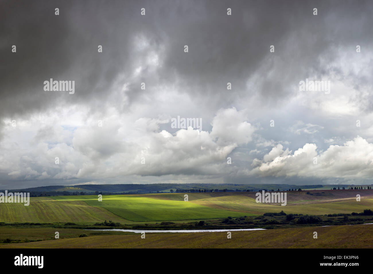 Farmland and lake during bad weather Stock Photo - Alamy