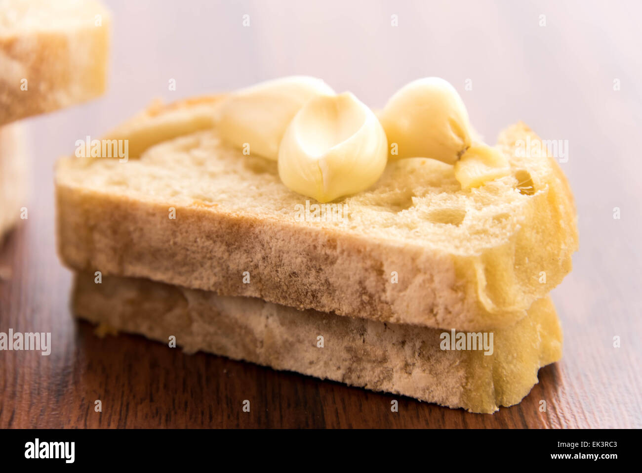 a fresh baked loaf of bread with whole cloves of roasted garlic Stock ...