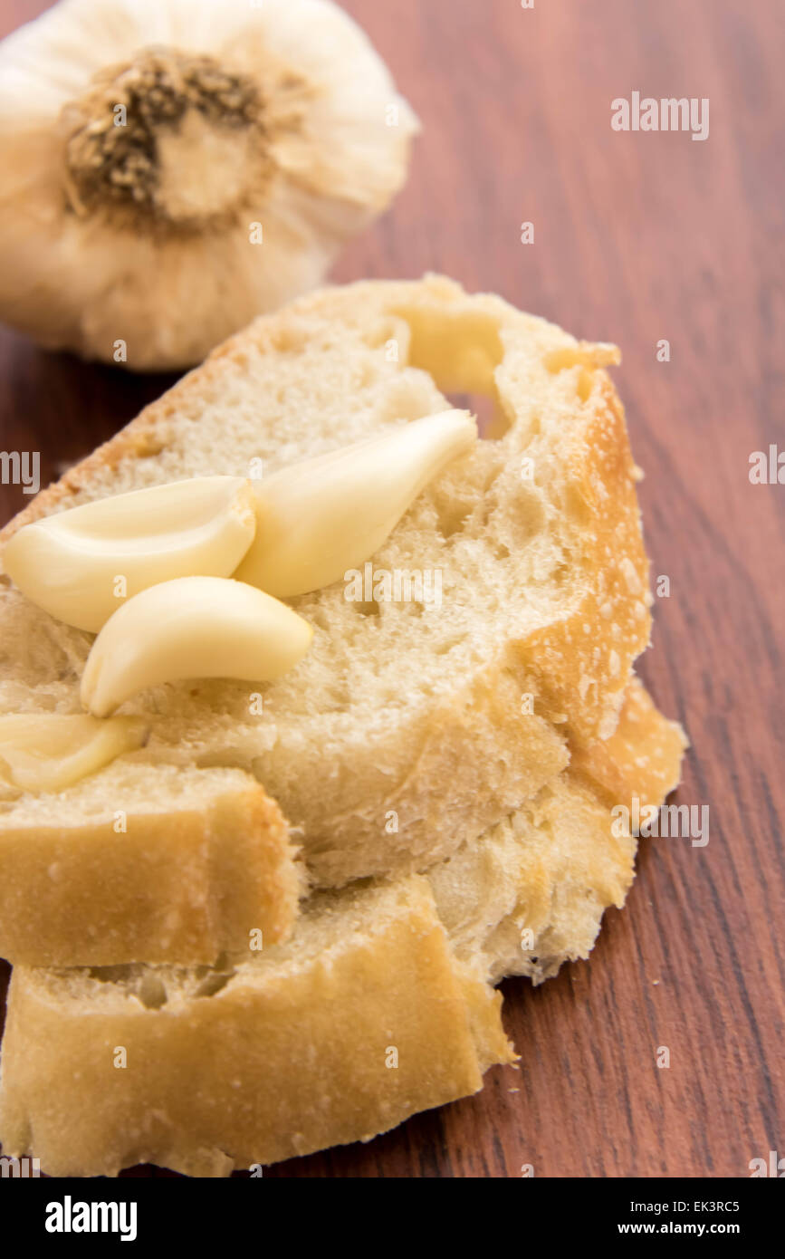 a fresh baked loaf of bread with whole cloves of roasted garlic Stock ...