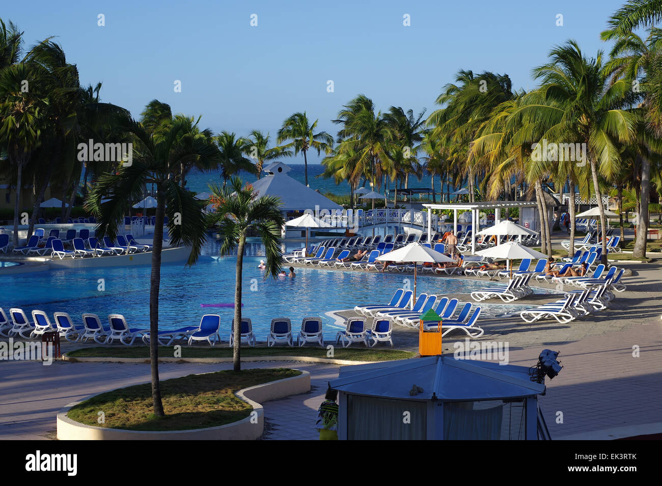 Lounge chairs around a swimming pool at a tropical resort Stock Photo ...
