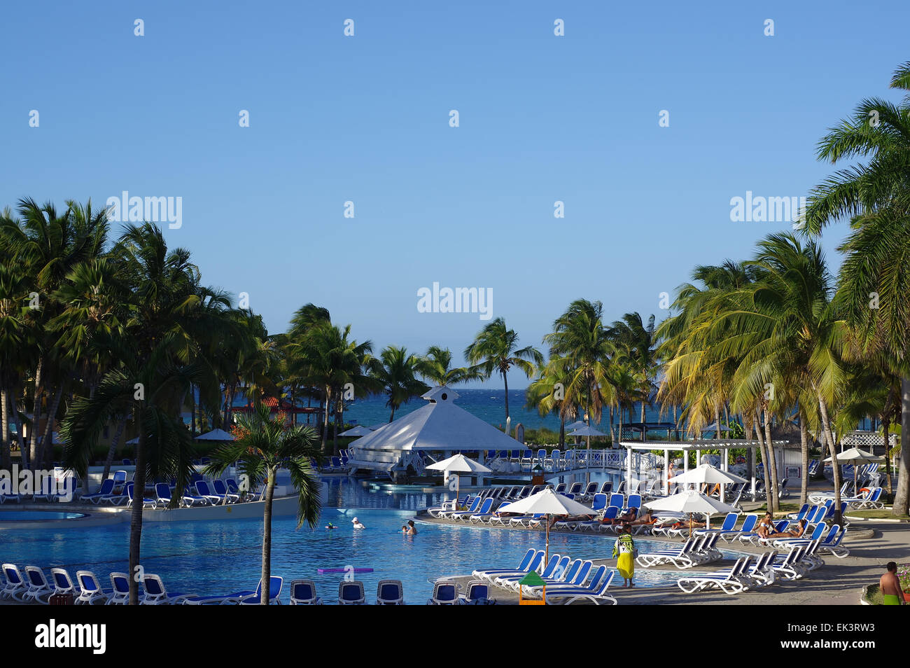 Lounge chairs around a swimming pool at a tropical resort Stock Photo ...