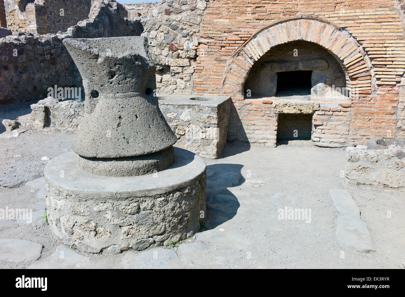 Millstone and oven at a bakery in the archaeological excavations of Roman Pompeii near Naples ...