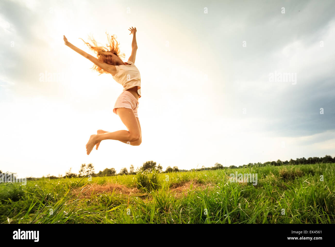 Happy girl jumping blue sky hi-res stock photography and images - Alamy
