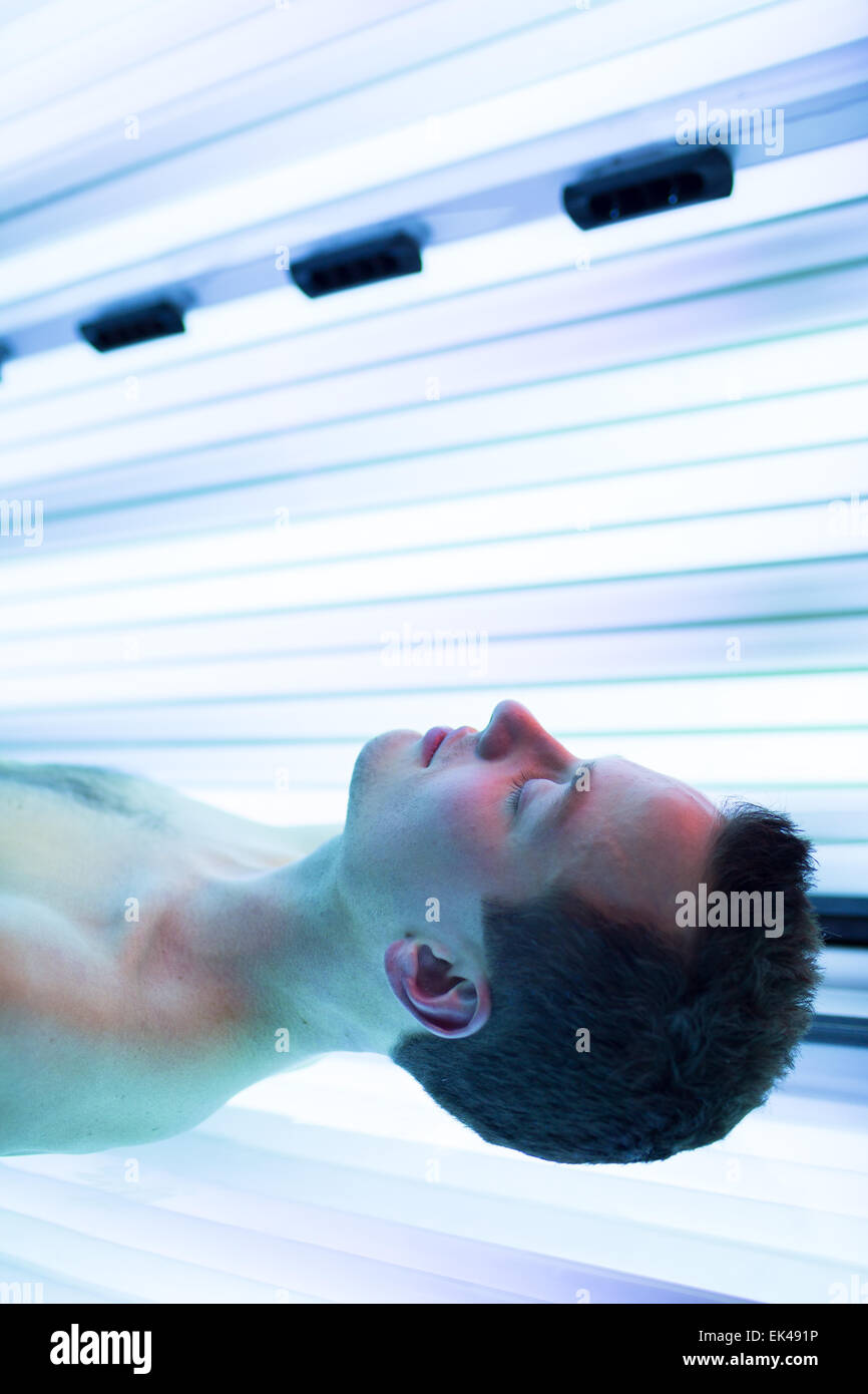 Handsome young man relaxing during a tanning session in a modern ...