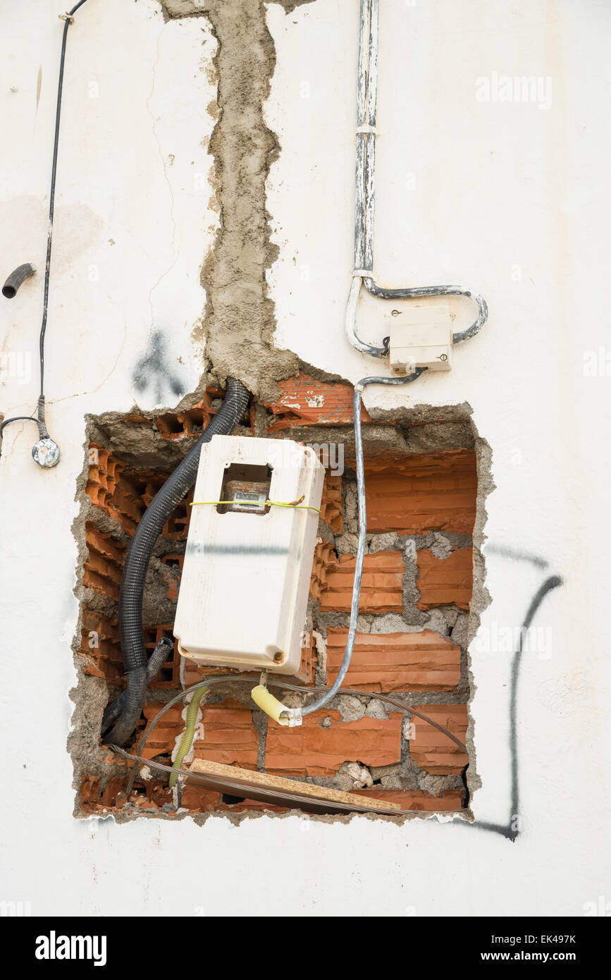 Unfinished wiring and electricity meter on a wall Stock Photo - Alamy