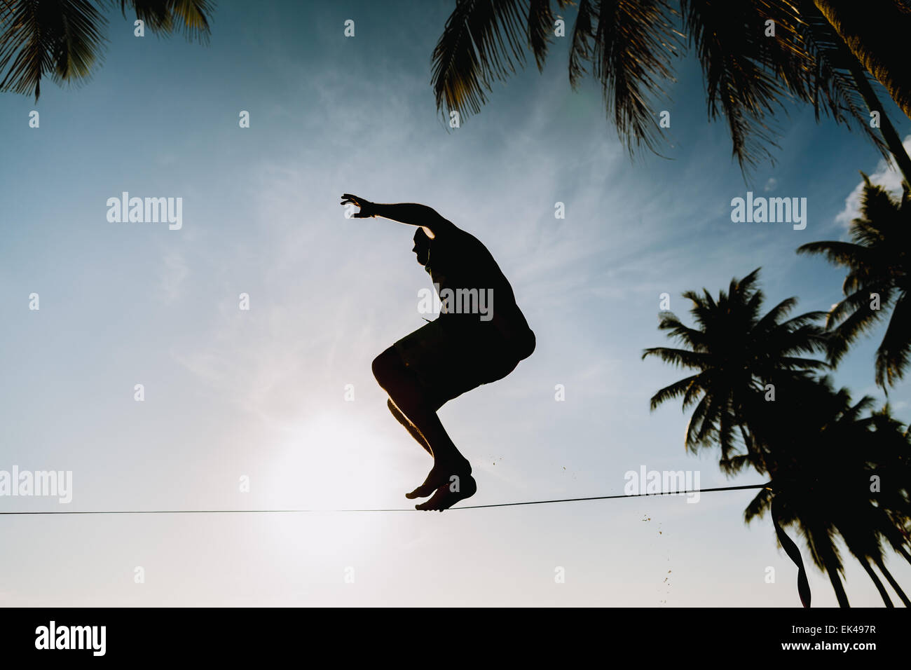 teenage balancing on slackline with sky view on the beach silhouette ...